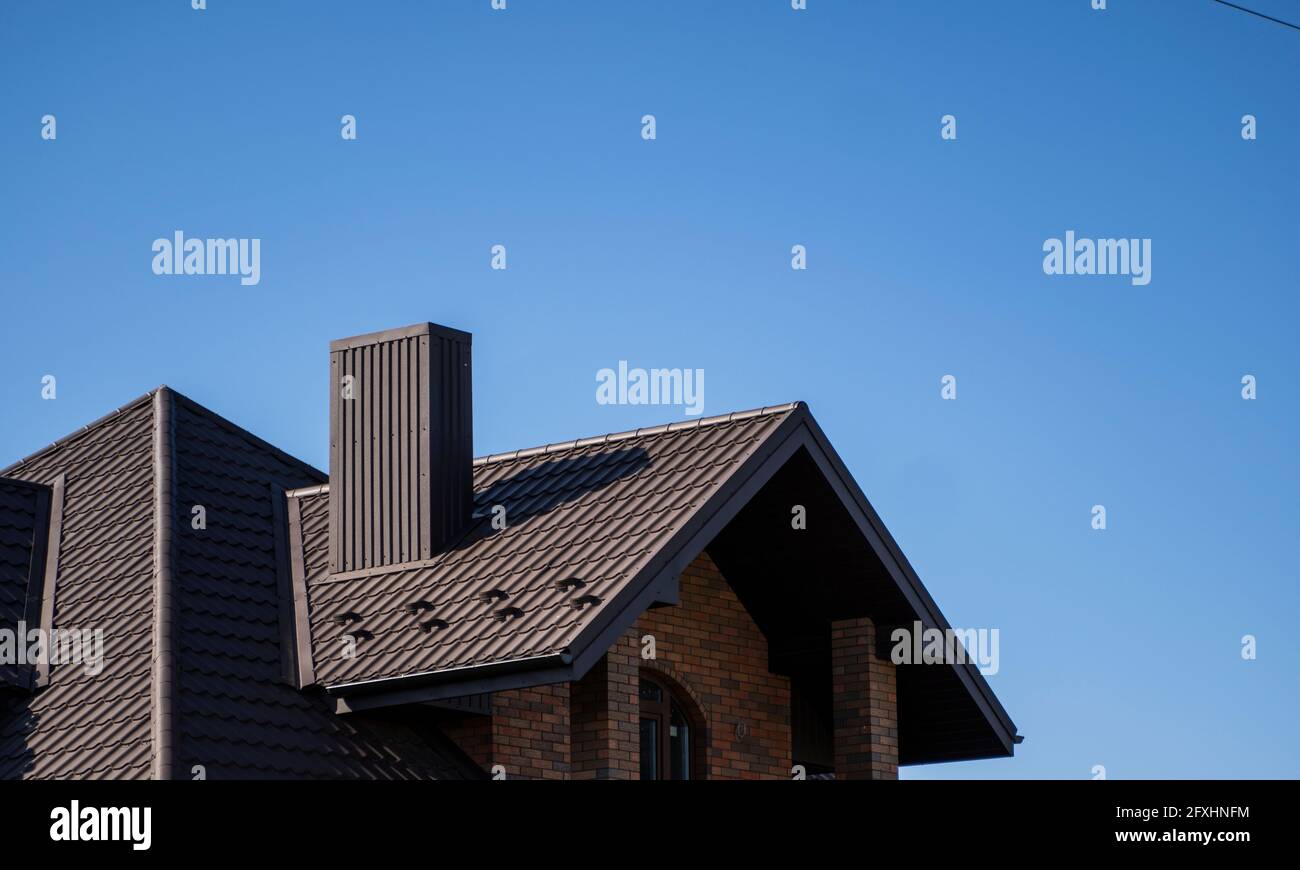 Brown corrugated metal profile roof installed on a modern house. The ...