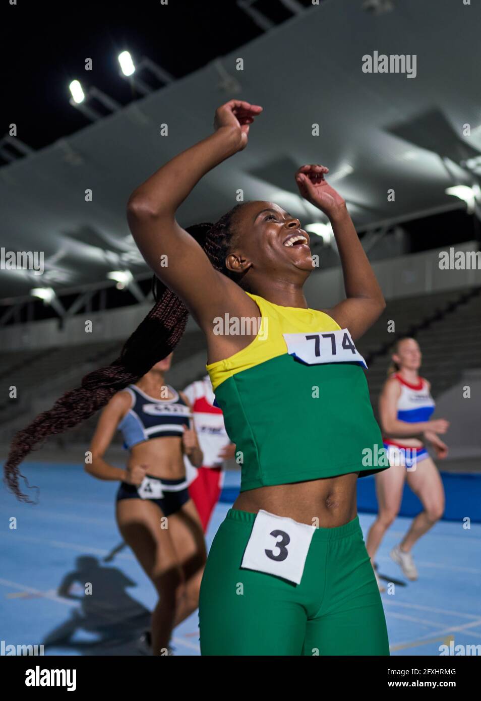 Happy female track and field athlete winning race Stock Photo - Alamy