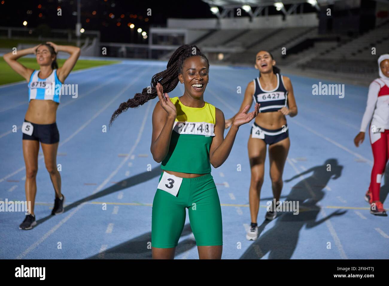 Happy female track and field athlete celebrating after race on track ...