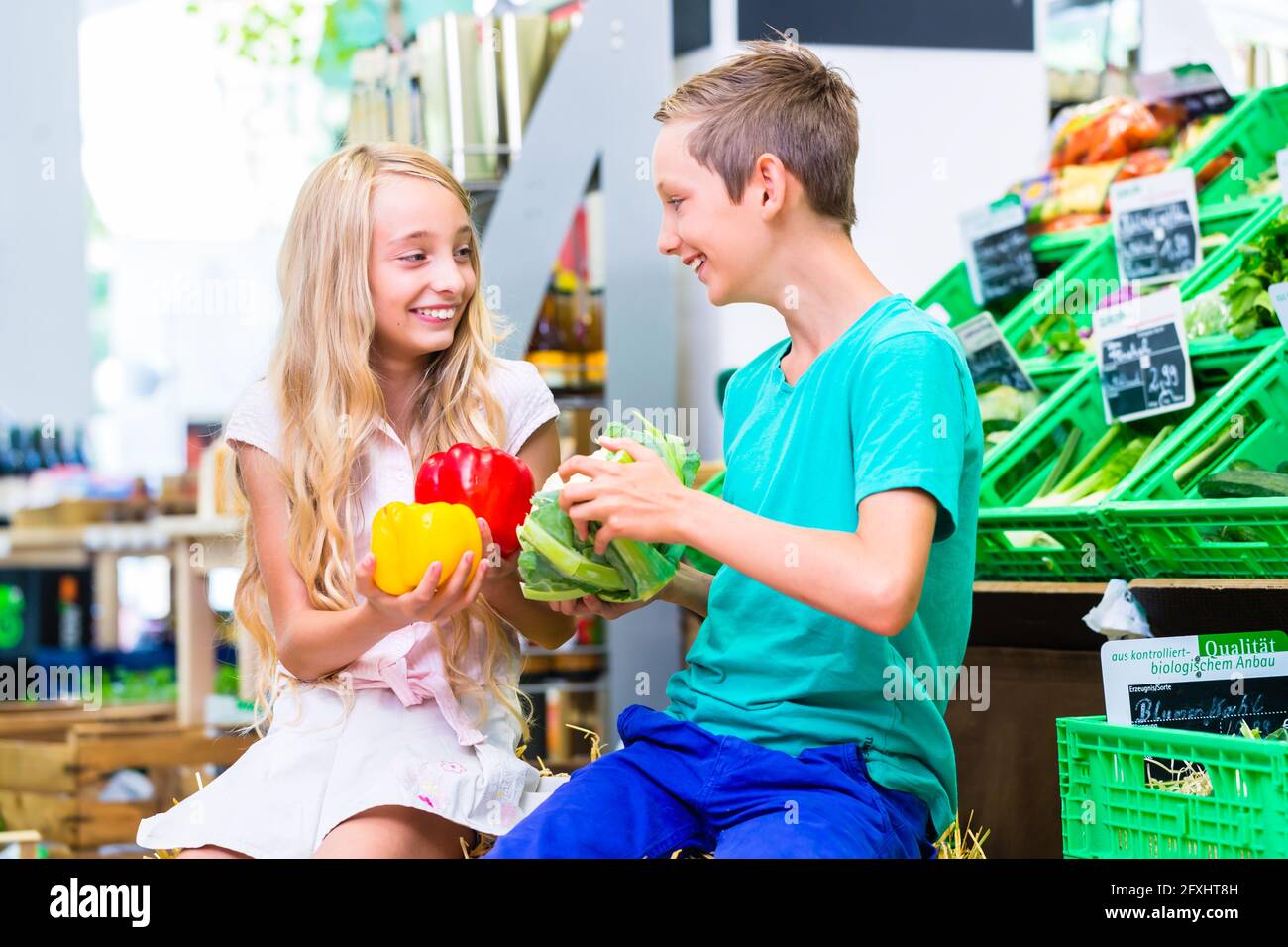 Children selecting vegetables while organic grocery shopping in ...
