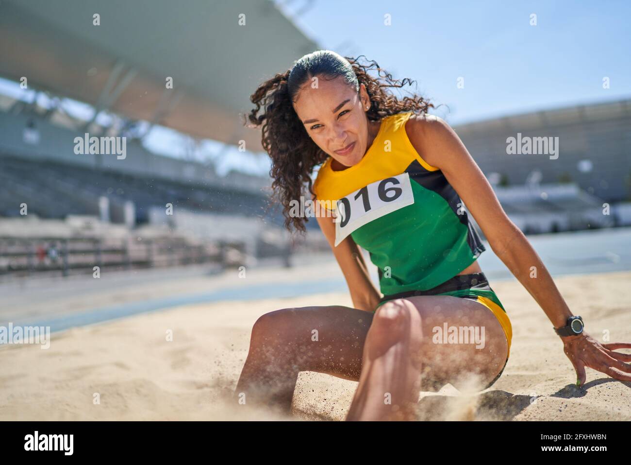 Female track and field athlete long jumping in sand Stock Photo - Alamy