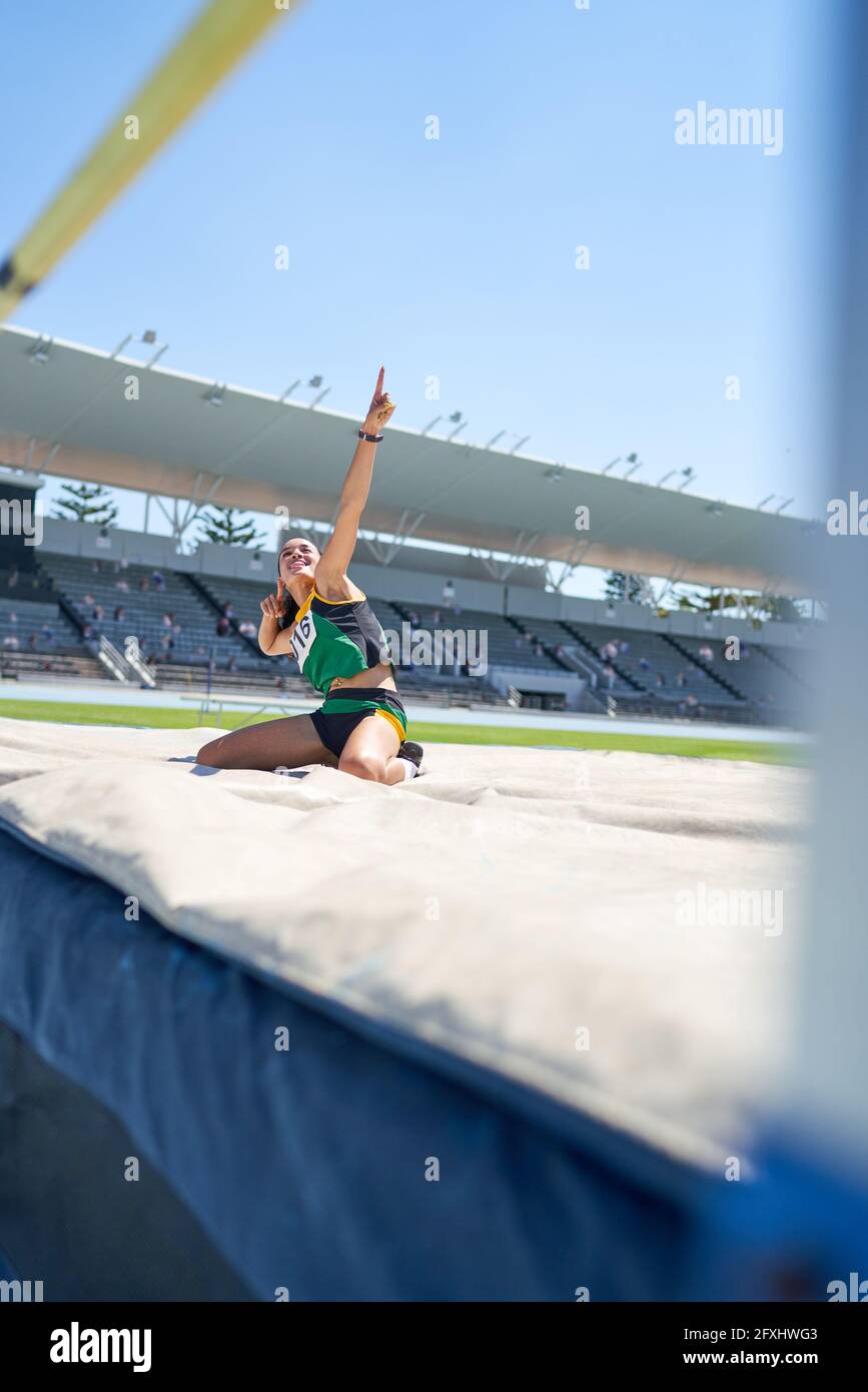 Happy female track and field athlete celebrating high jump Stock Photo ...