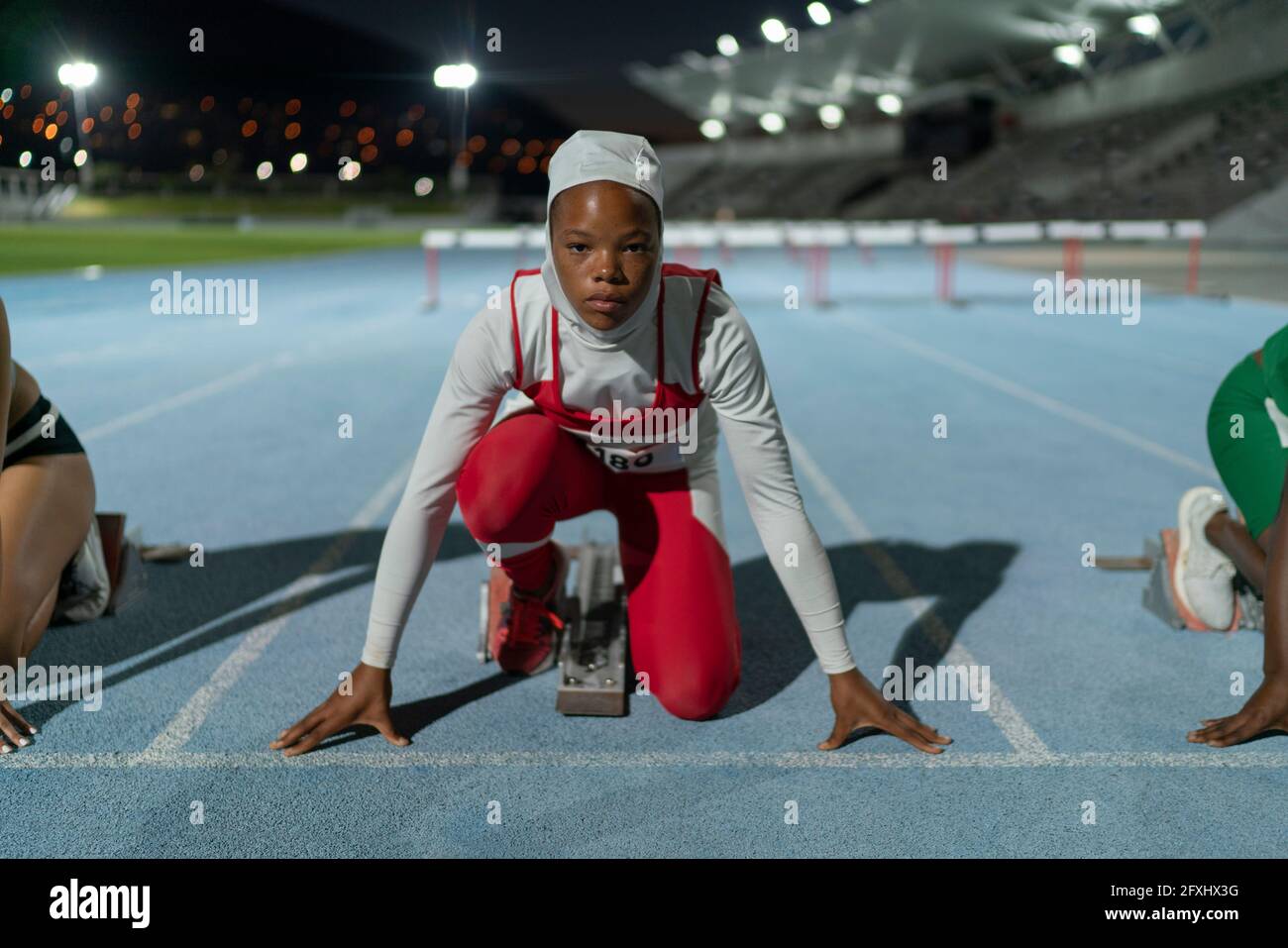 Portrait determined female runner in hijab at track starting line Stock ...