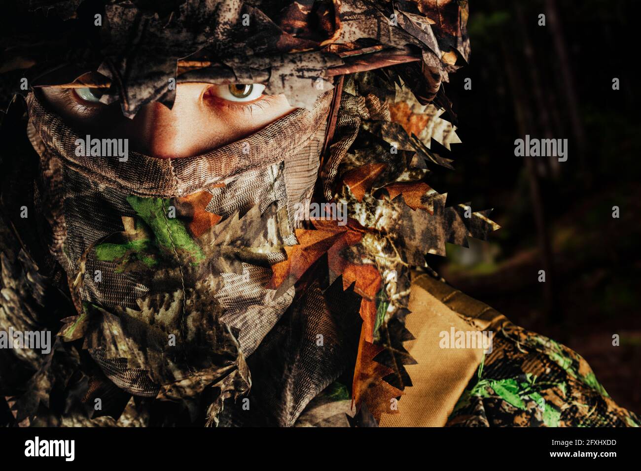 Photo of a male hunter face in panama hat and guillie forest ...