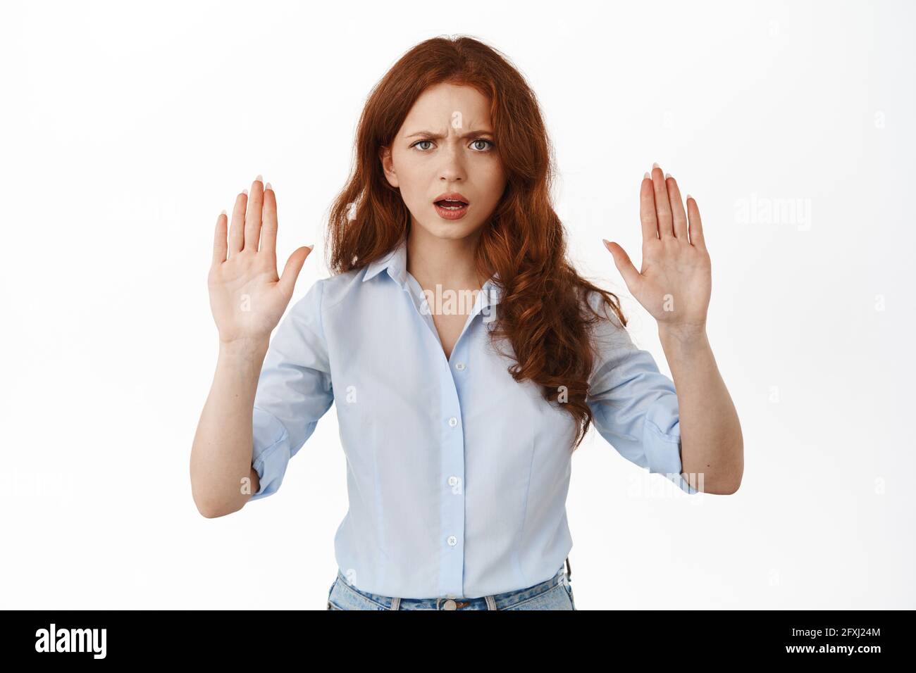 Stop, keep distance. Angry redhead woman showing block no gesture ...