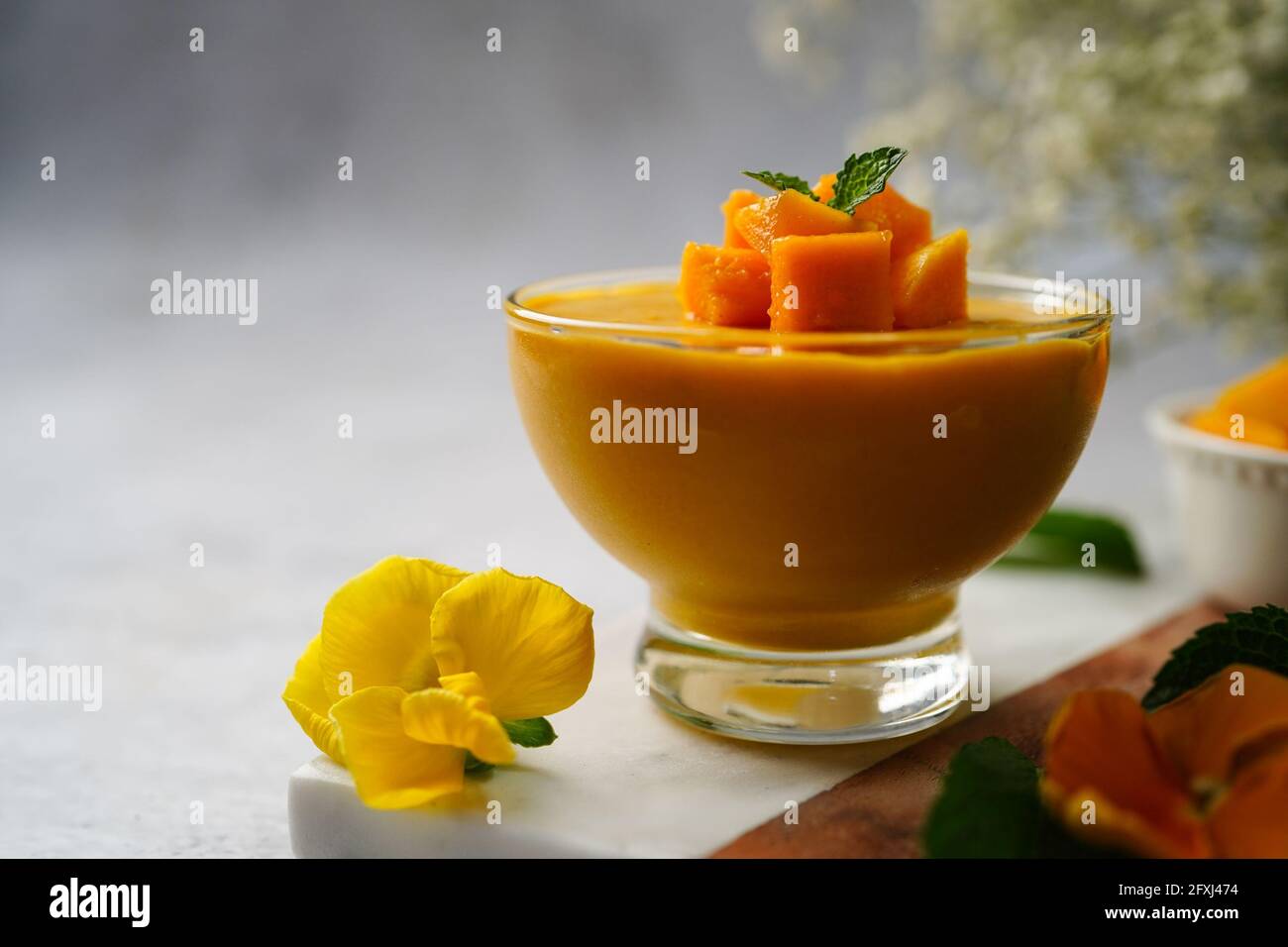 Homemade Mango Mousse with cut mangoes and mint garnish, selective ...