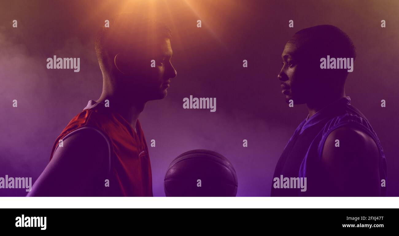 Composition of two basketball players holding ball on purple tinted ...