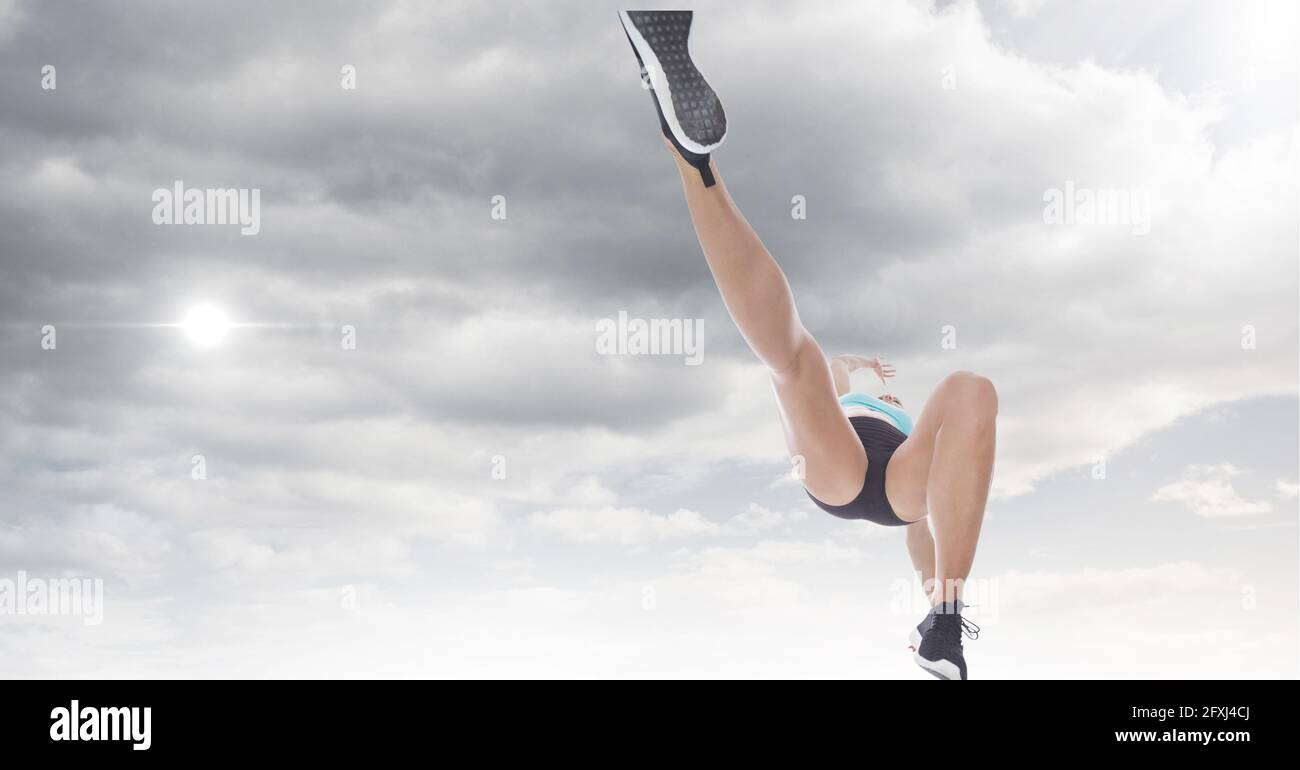 Composition of caucasian female high jumper in the air with copy space ...