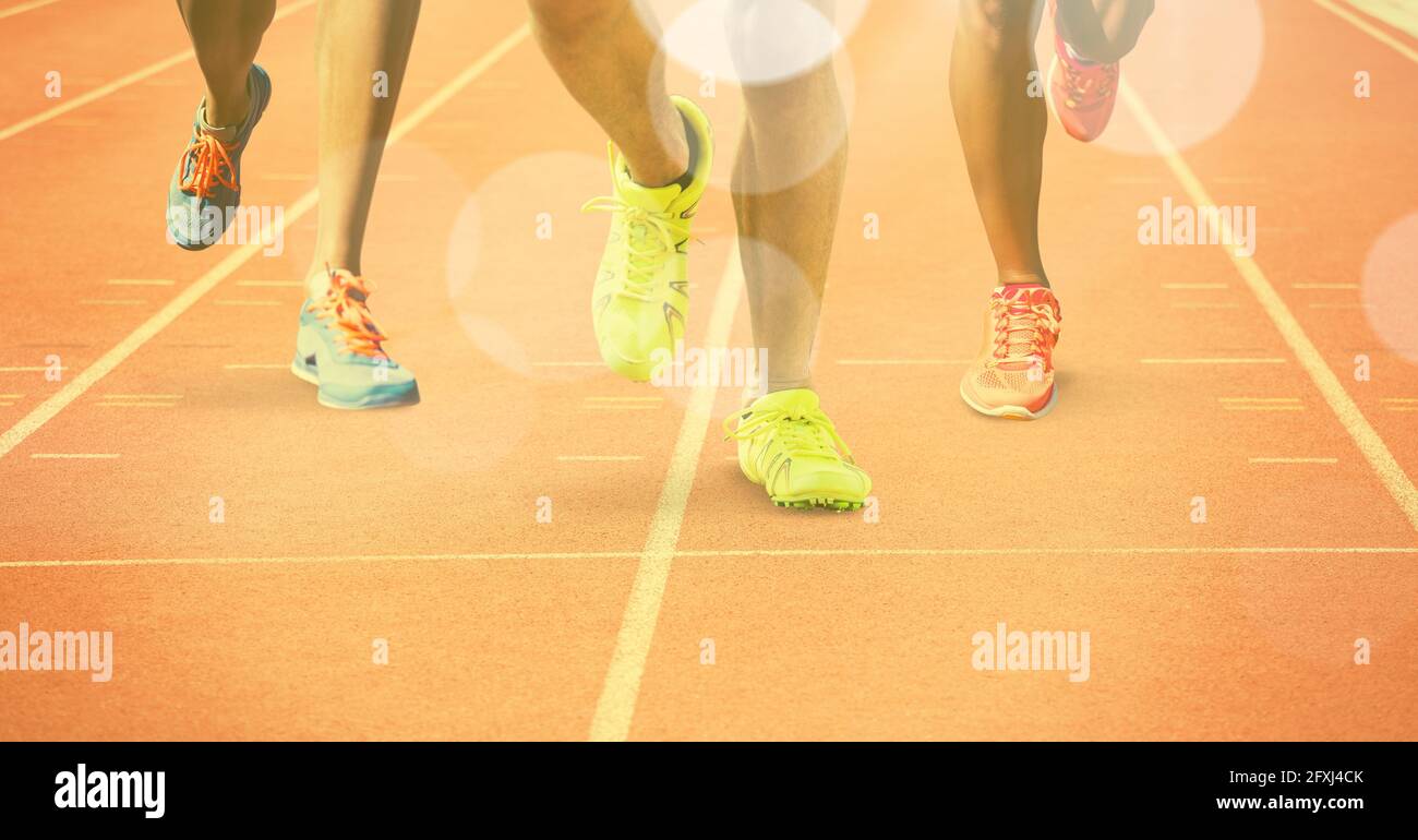 Composition of legs of athletes running on racing track with spots of ...