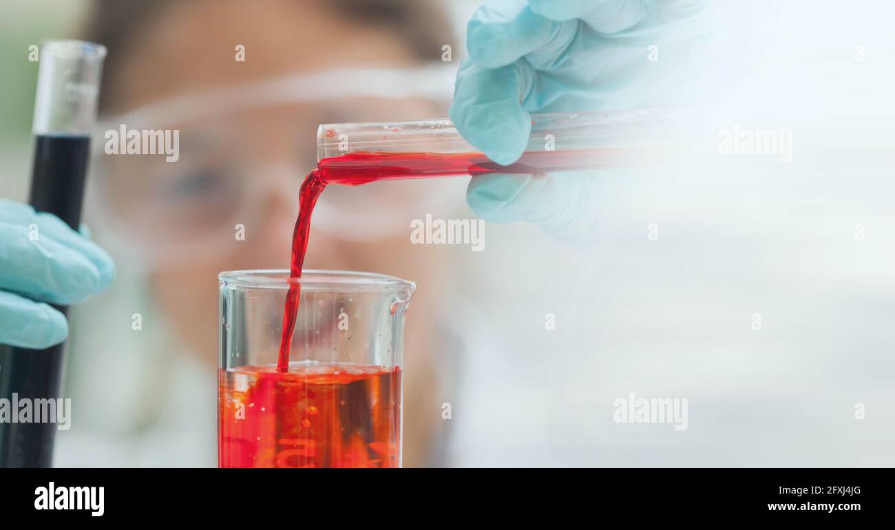 Composition of female scientist holding test tube with red liquid in ...