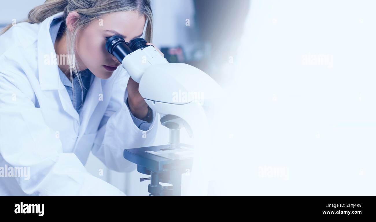 Composition of female lab technician using microscope, with blurred ...