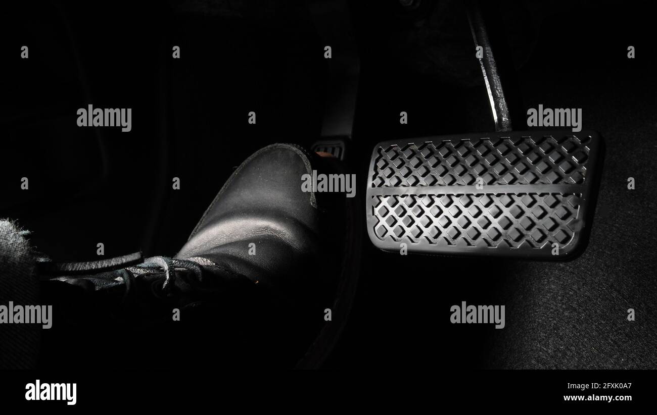 Foot pressing foot pedal of a car to drive. Accelerator and brake pedal ...