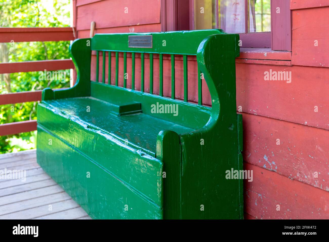 A green color colonial style wooden bench in house porch. Black Creek ...