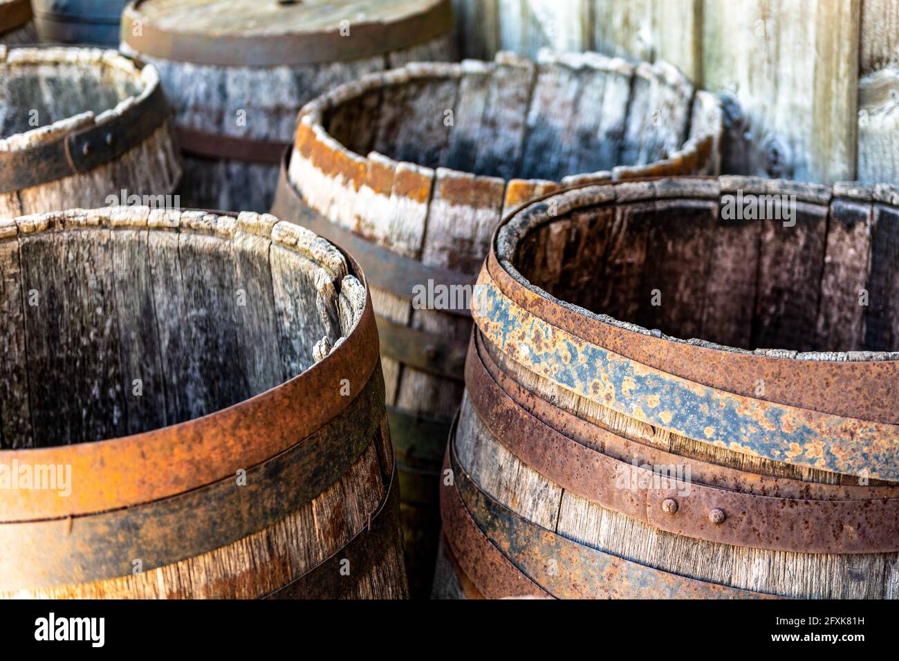 Antique colonial barrels which are weathered by being outdoors in a ...