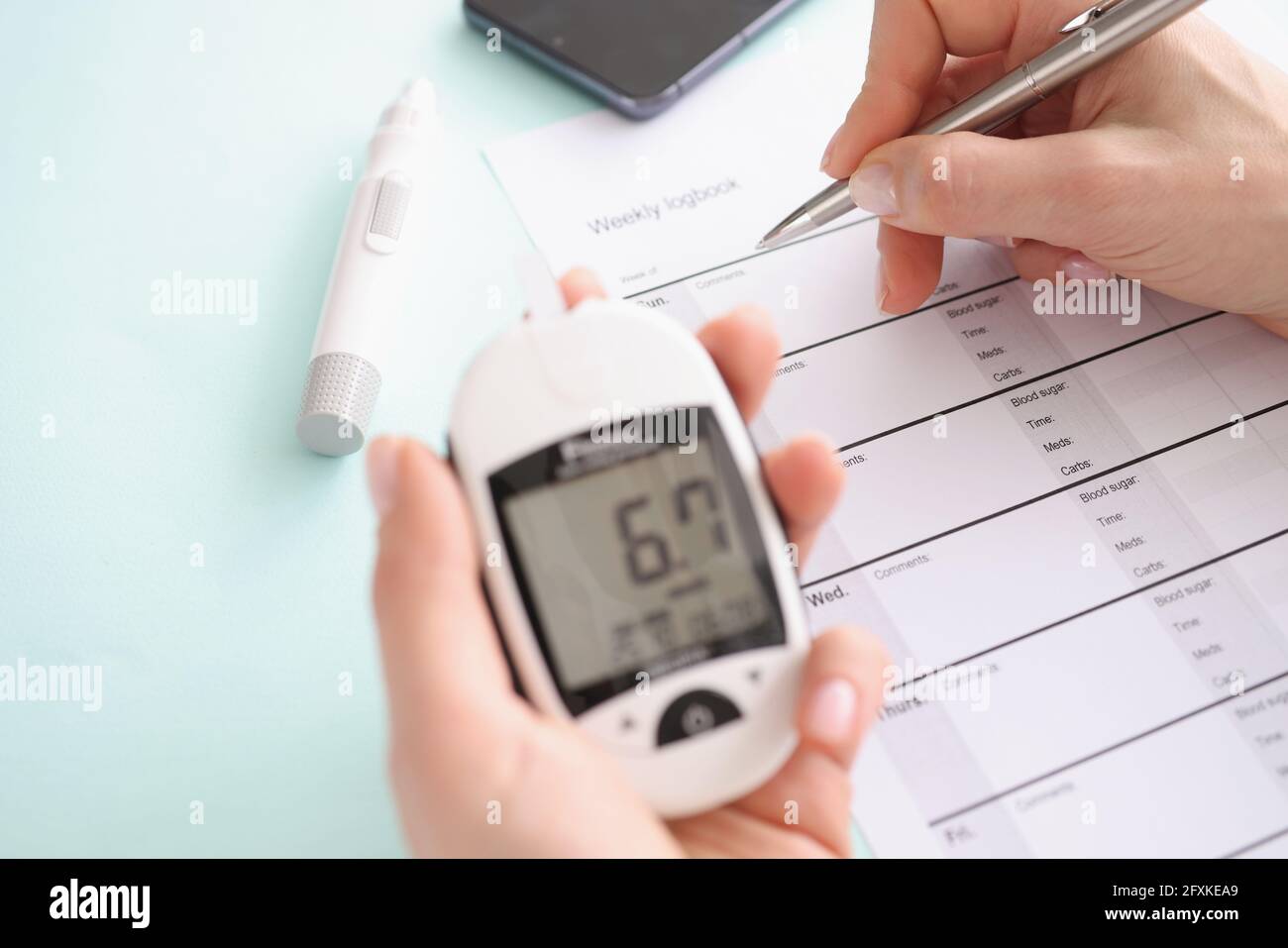 Glucometer with blood test results in patient hand fills in results in ...