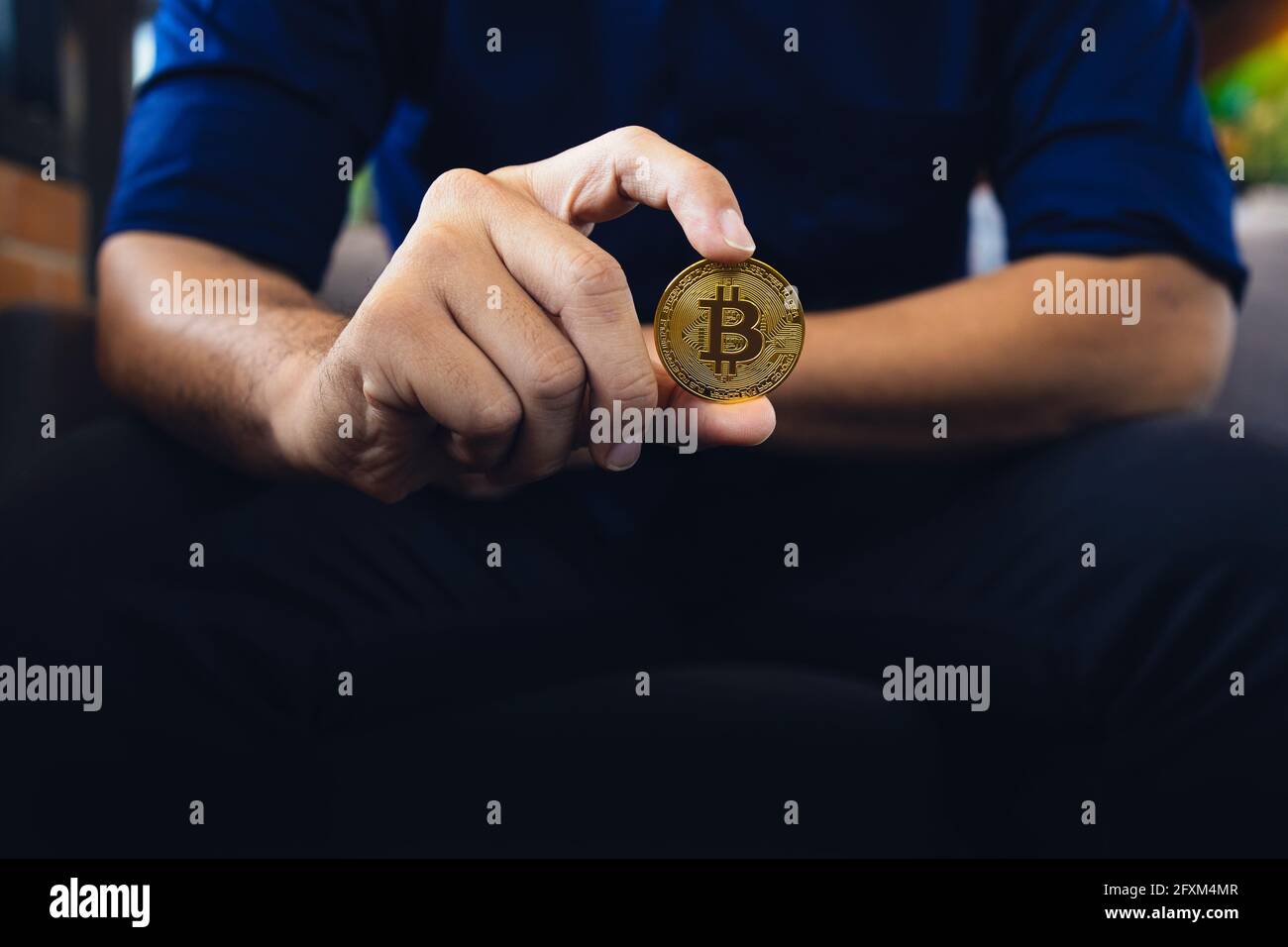 golden bitcoin in a businessman hand in the office with soft focus and ...