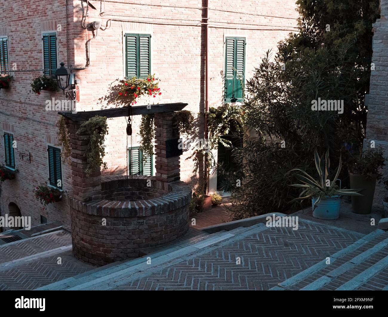 A medieval brick water well in the middle of a staircase in an ancient ...