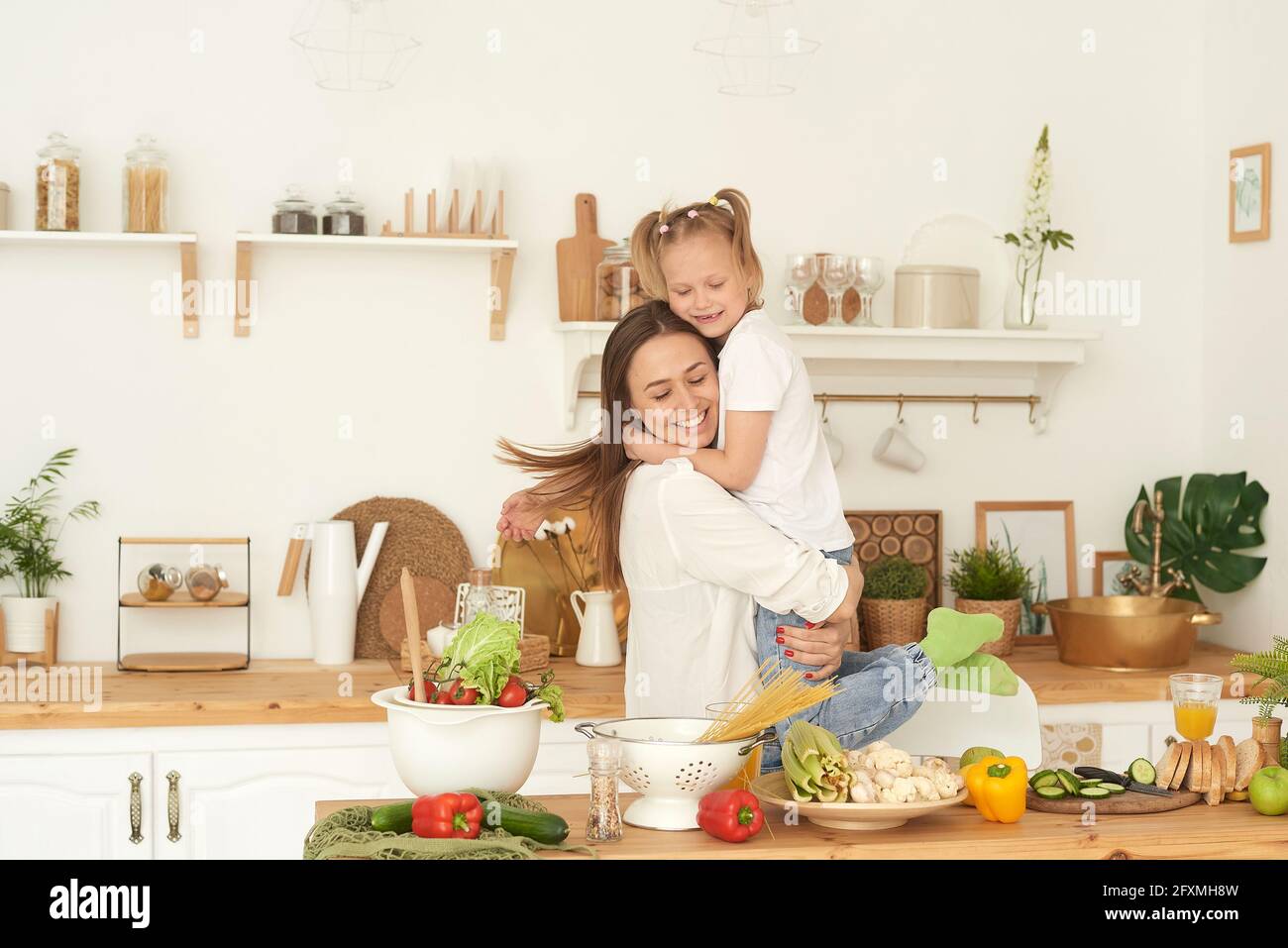Happy family healthy life concept. Mom hugs her daughter in the kitchen ...