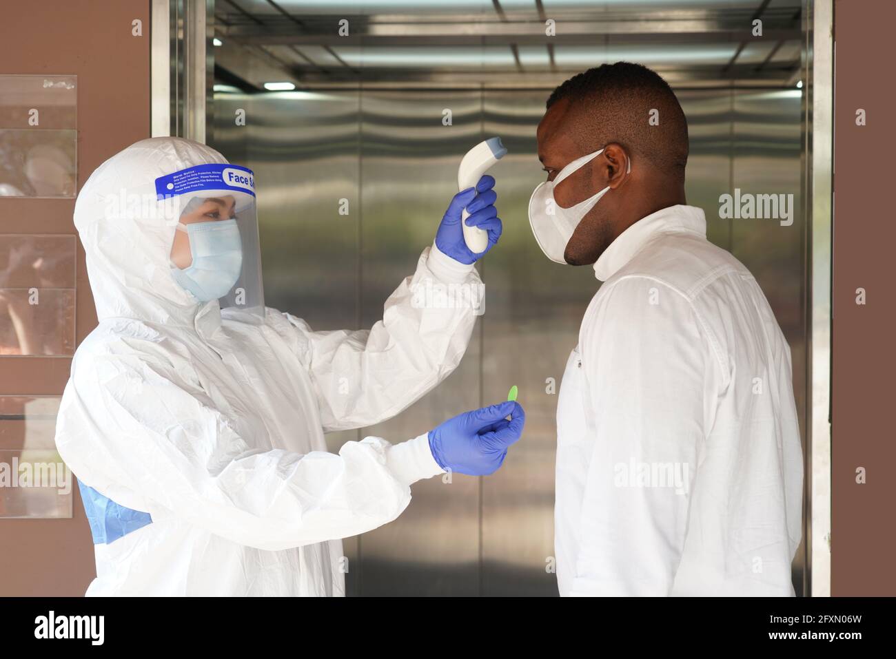 Disease control experts use an Infrared thermometer equipment to check ...