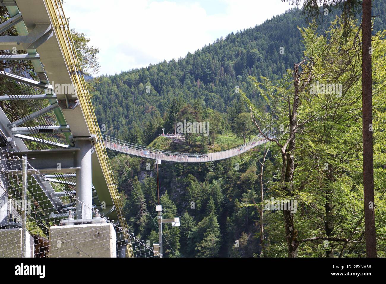Side view of a suspension bridge in Reutte, Austria under a cloudy sky ...