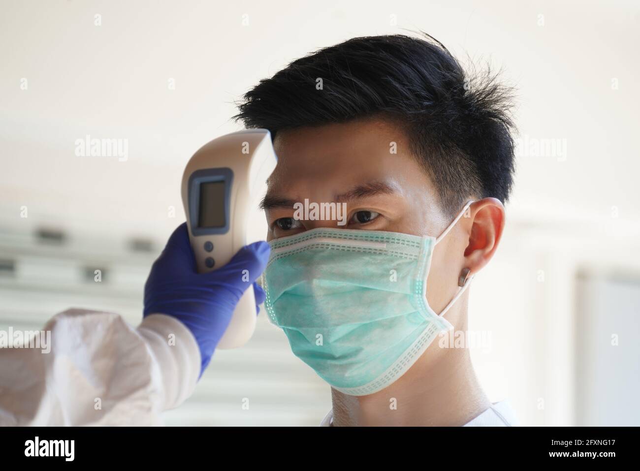 Disease control experts use an Infrared thermometer equipment to check the temperature on the ...