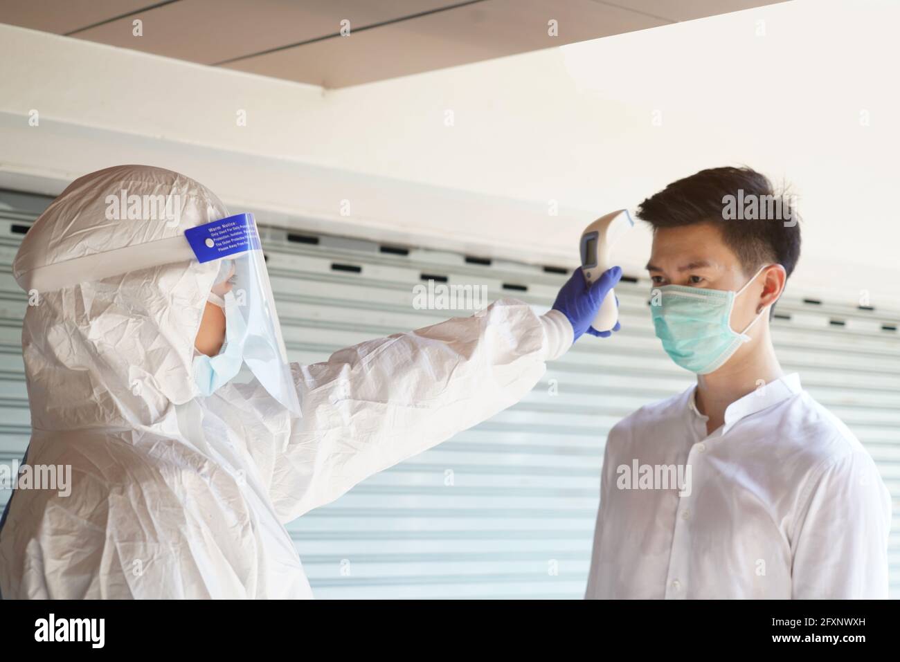 Disease control experts use an Infrared thermometer equipment to check ...