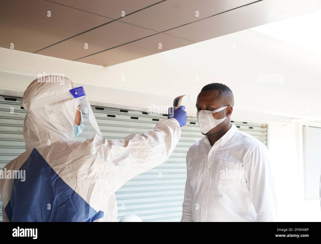 Disease control experts use an Infrared thermometer equipment to check ...