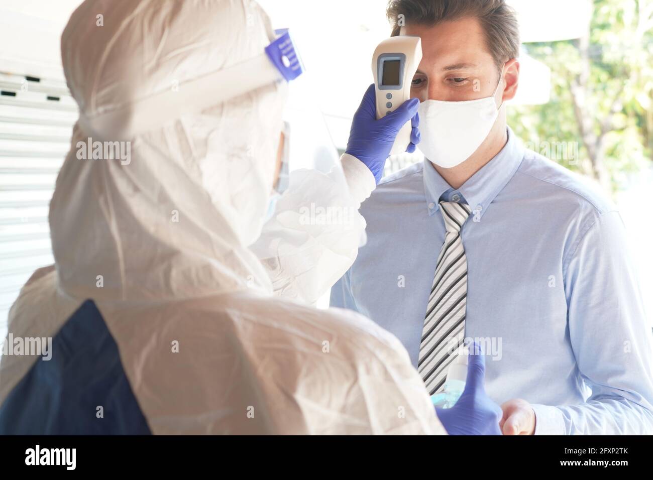 Disease control experts use an Infrared thermometer equipment to check ...