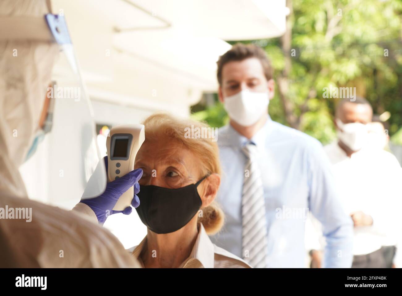 Disease control experts use an Infrared thermometer equipment to check ...