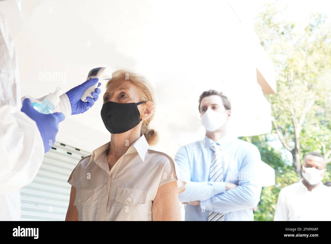Disease control experts use an Infrared thermometer equipment to check ...