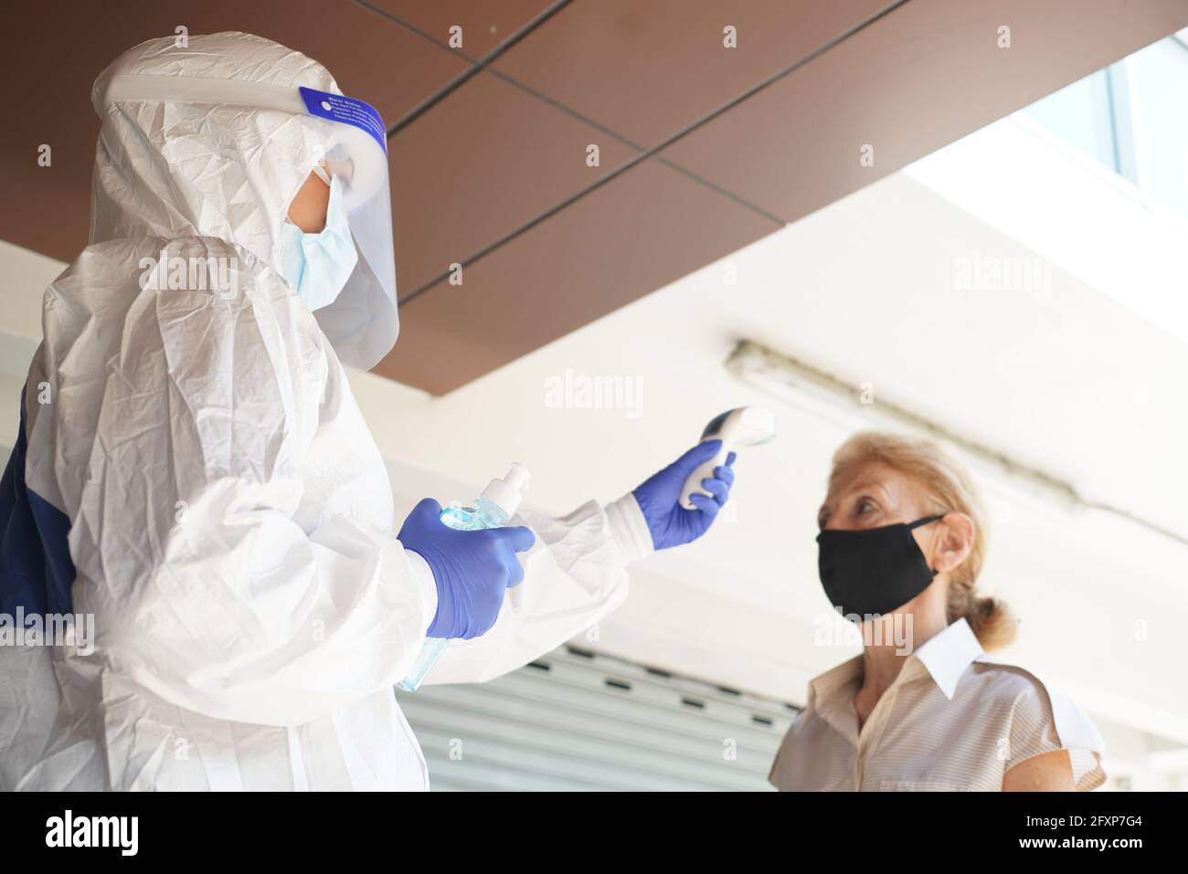 Disease control experts use an Infrared thermometer equipment to check ...