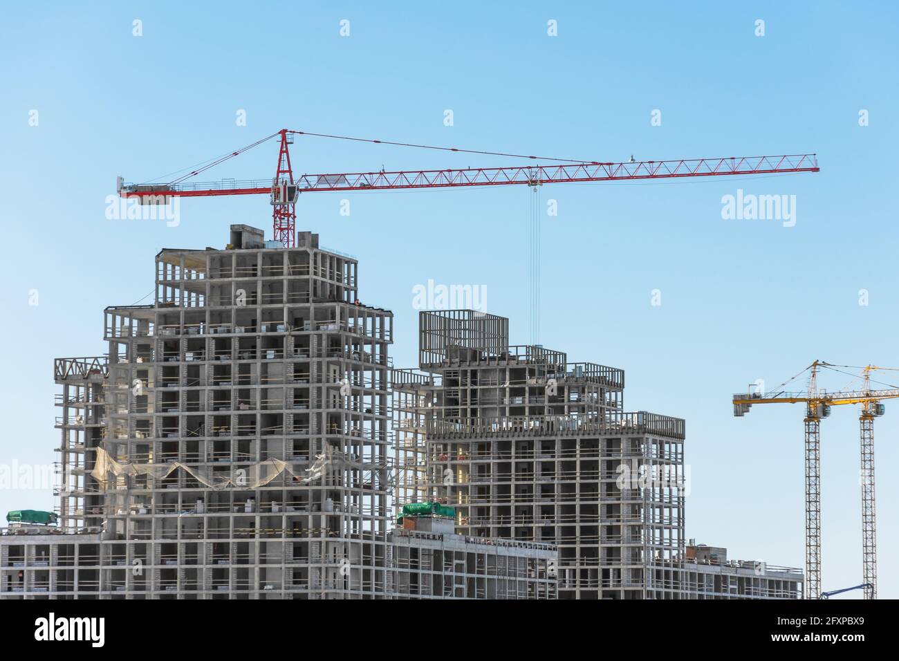 View of a residential complex under construction with high cranes ...