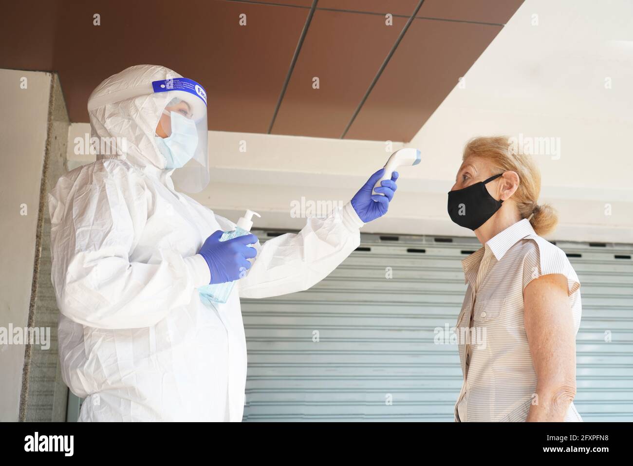 Disease control experts use an Infrared thermometer equipment to check ...