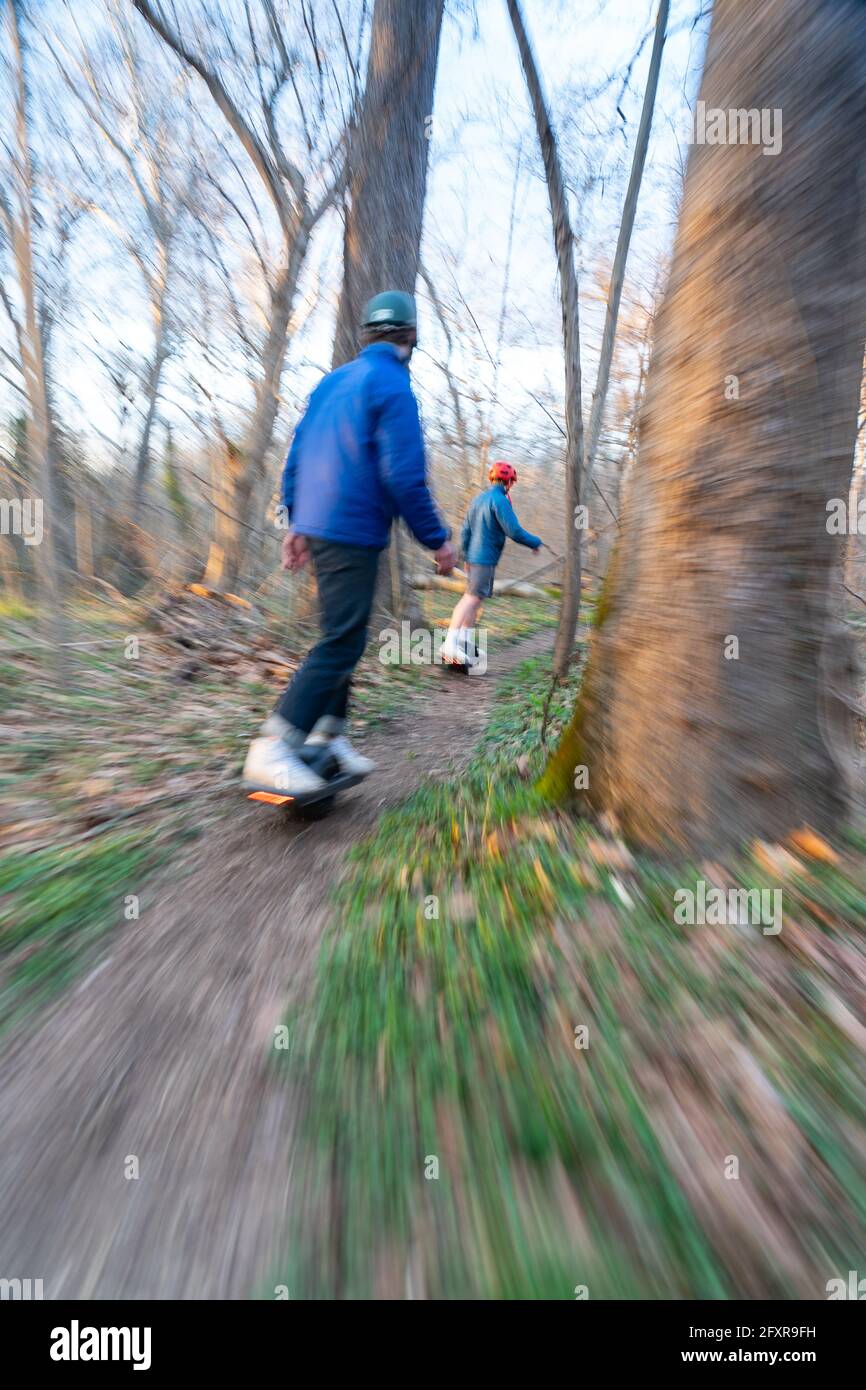 Brothers ride their One-Wheels on a single track mountain biking trail ...