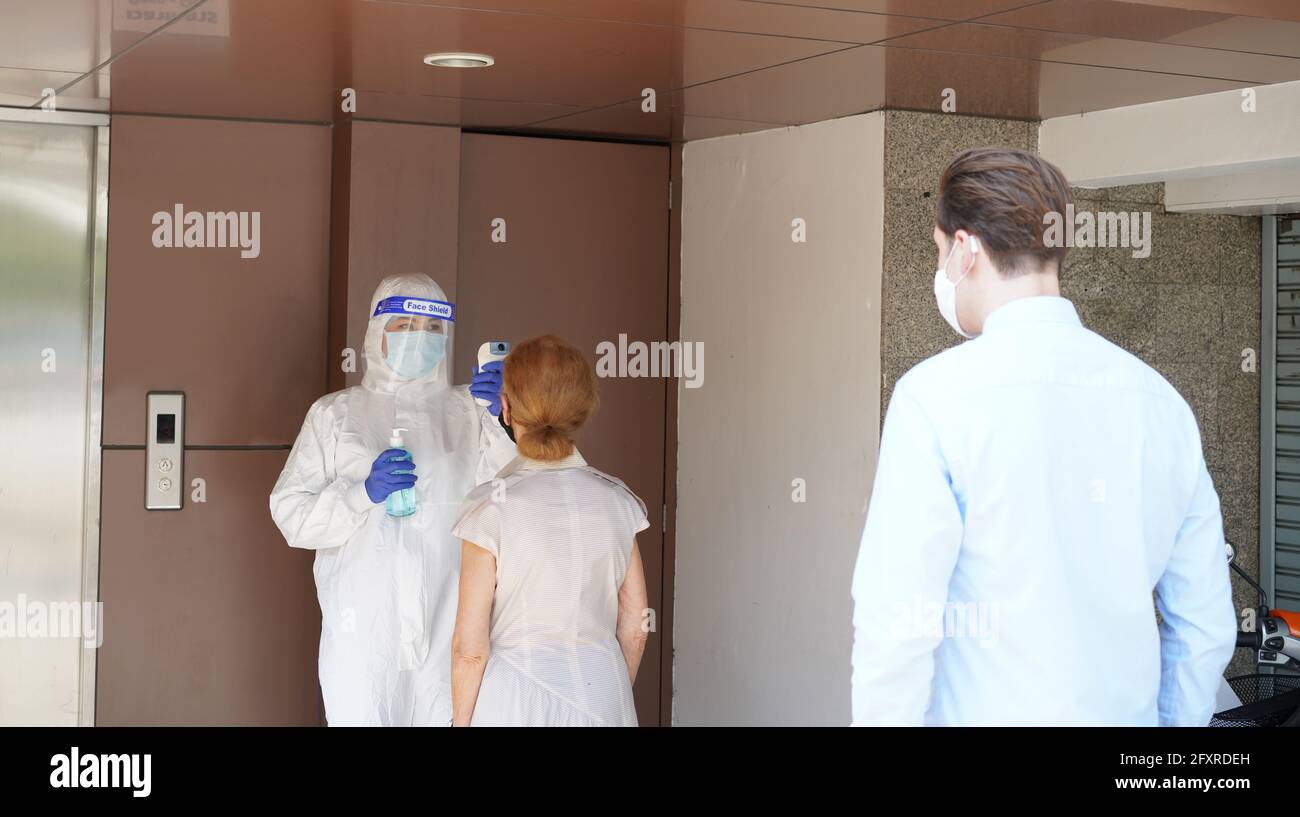 Disease control experts use an Infrared thermometer equipment to check ...