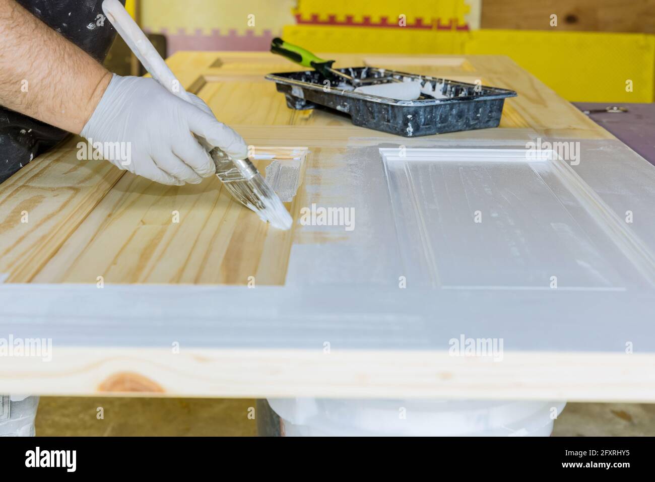 Woodwork master processes for painting wooden doors Stock Photo - Alamy