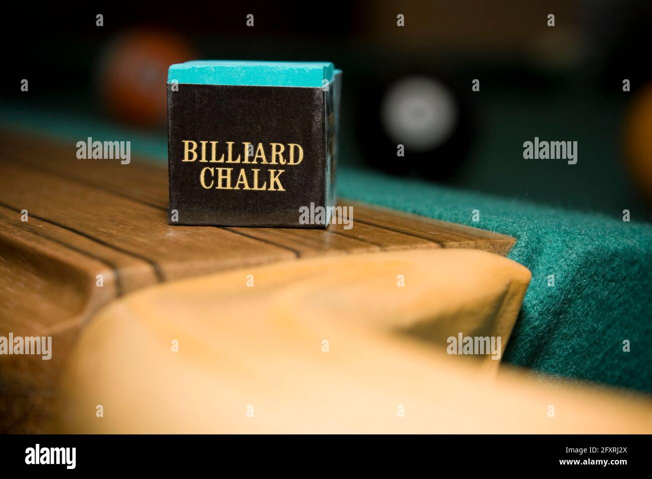 Close up shot of billiard chalk on pool table with balls in background ...