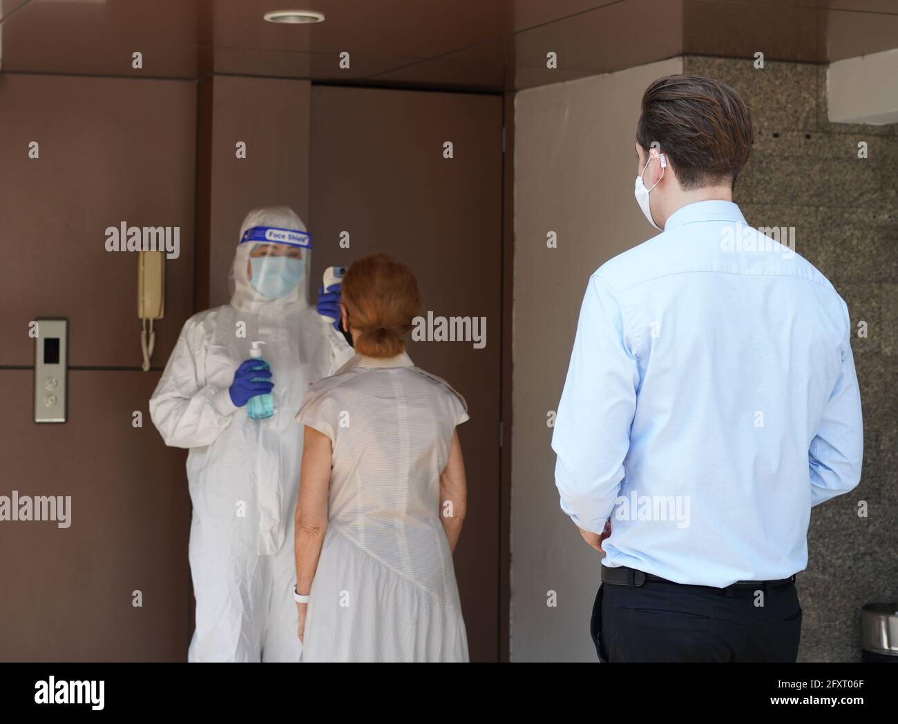 Disease control experts use an Infrared thermometer equipment to check ...