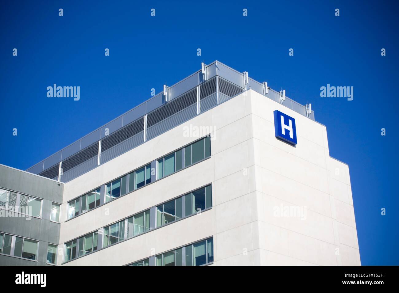 Modern hospital against deep blue sky shot in summer Stock Photo - Alamy