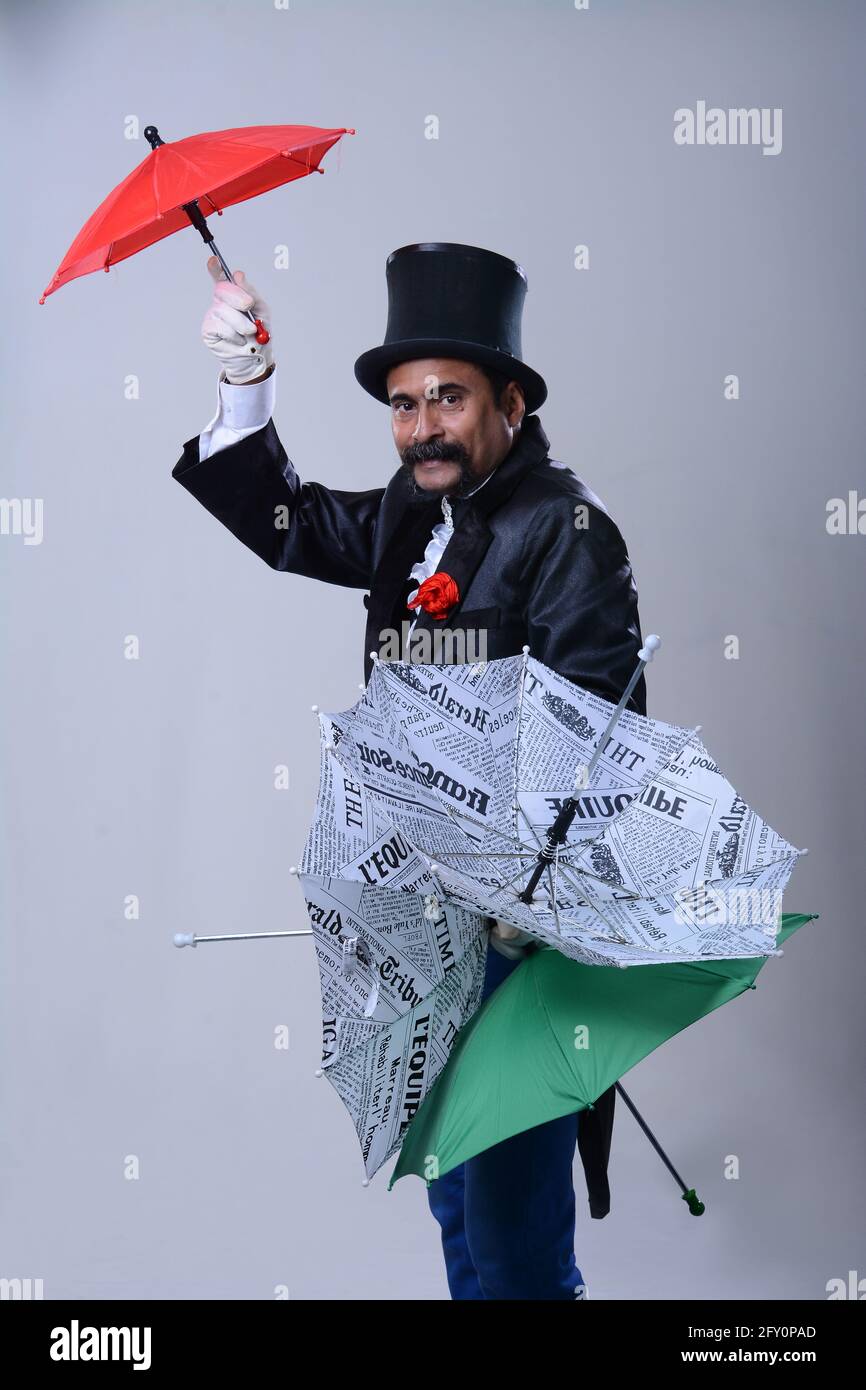Magician doing tricks with umbrellas on white background Stock Photo ...