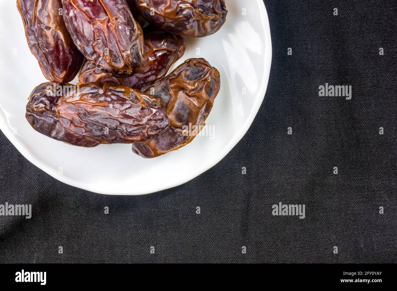 Big luxury dried date fruit in bowls on the dark surface, kurma ramadan ...