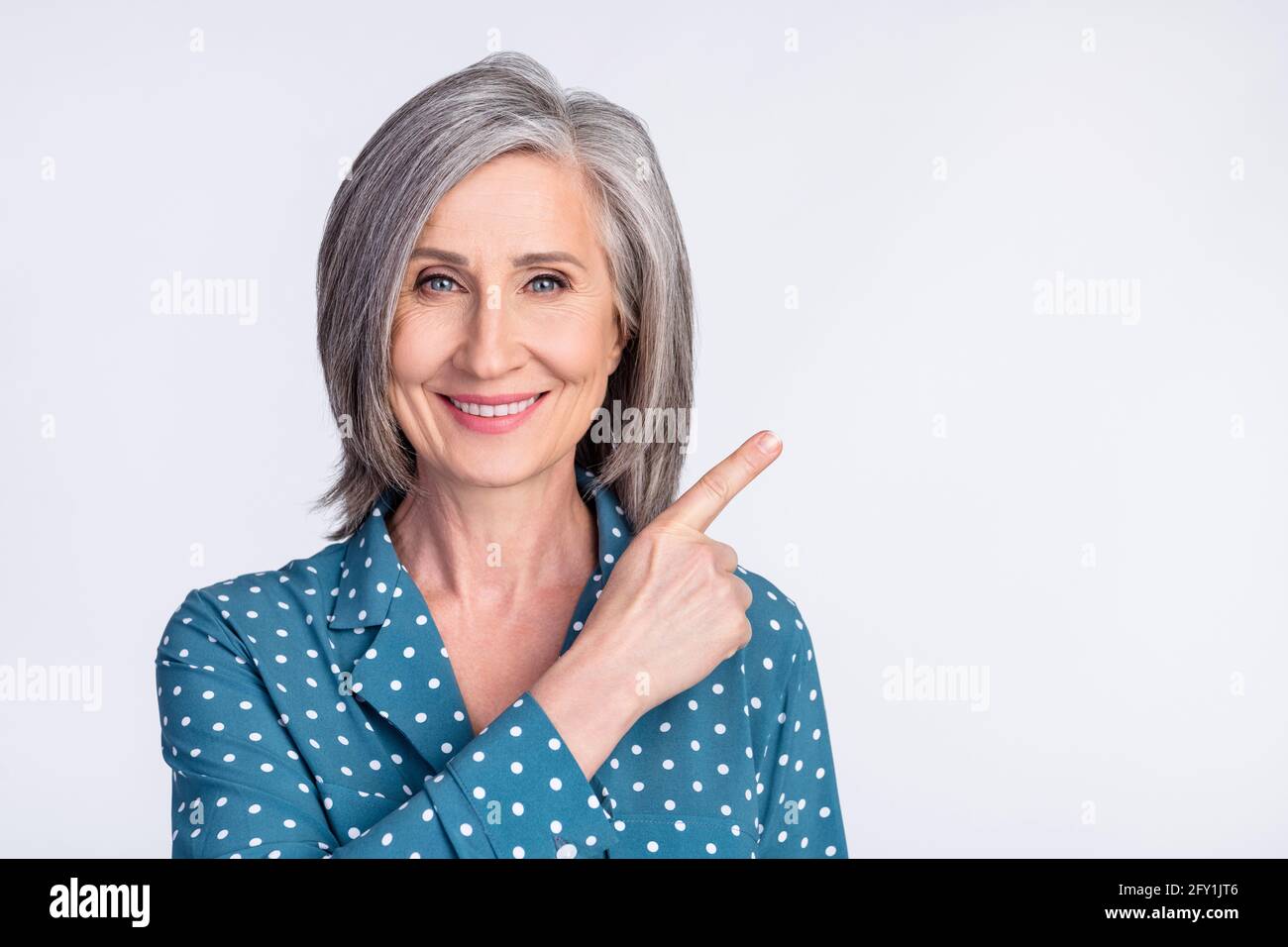 Photo portrait of elder business lady pointing finger blank space ...