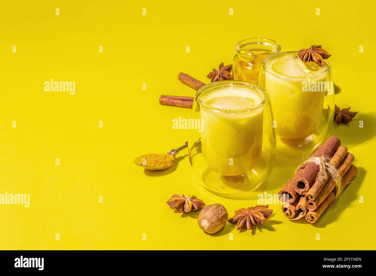 Golden turmeric milk with ice. Cinnamon, nutmeg, anise spices. Trendy ...