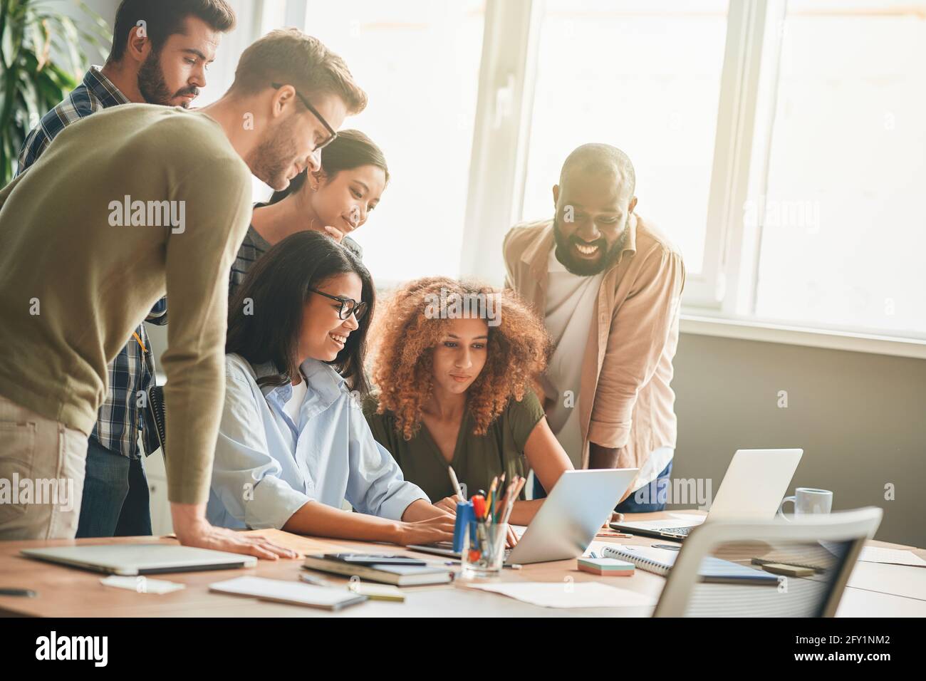 Friendly young people showing support to their office colleague Stock ...