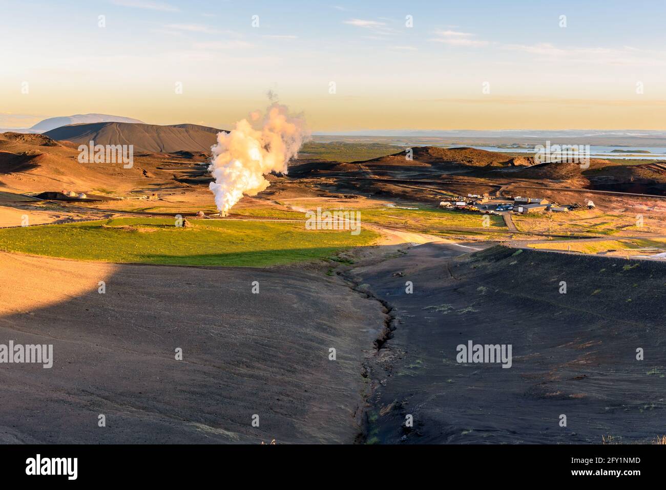 Geothermal power plant in a dramatic volcanic landscape at sunset. A ...