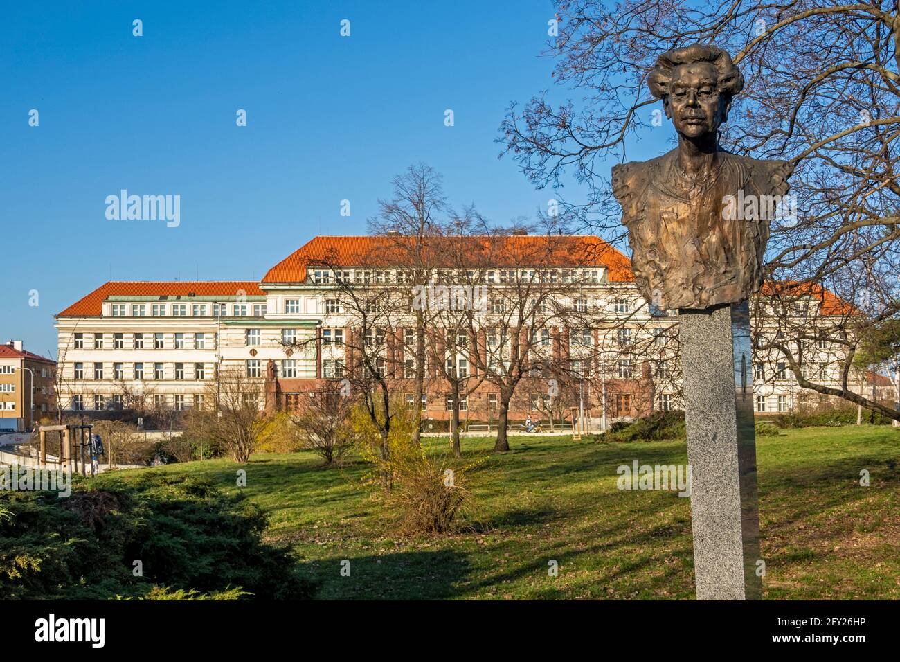 A bronze bust of Milada Horakova, standing in a park near building of ...