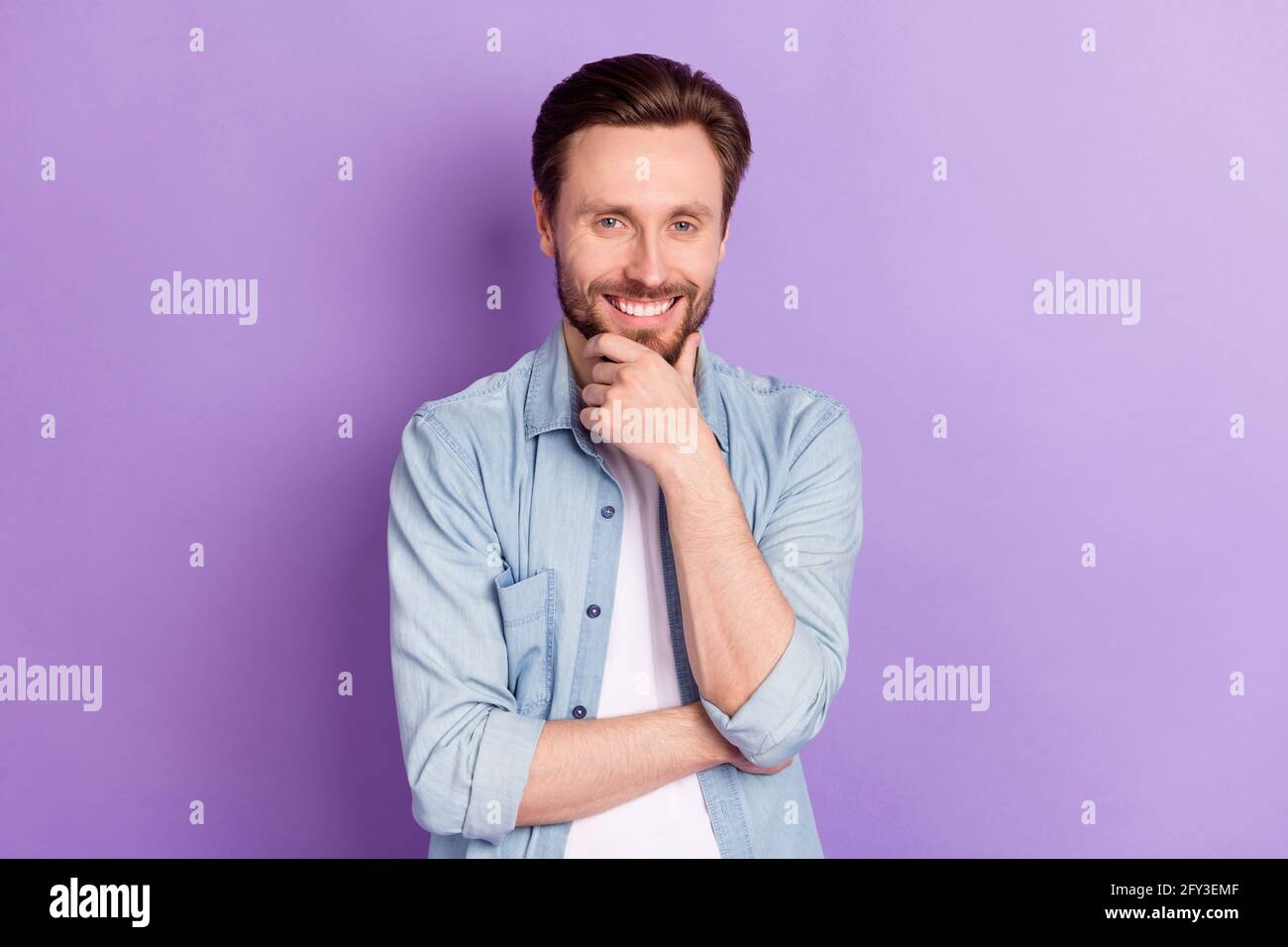Photo of positive cheerful young man hold hand chin smile minded ...