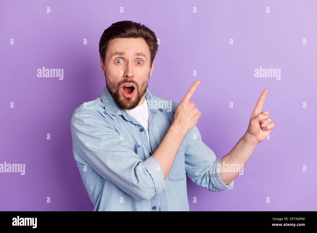 Photo of young shocked amazed surprised man point fingers copyspace ...