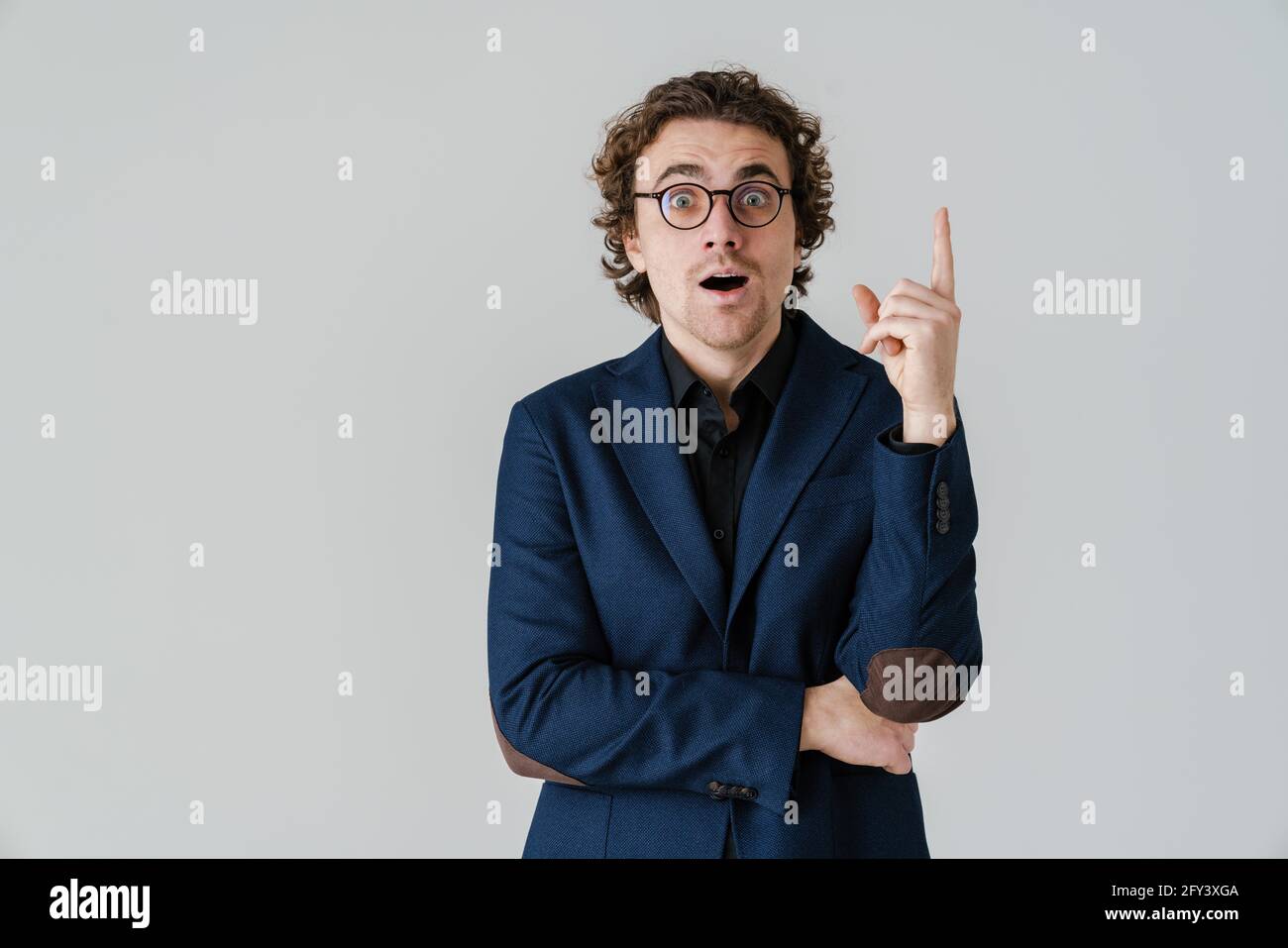 Shocked handsome man in eyeglasses exclaiming and pointing finger ...