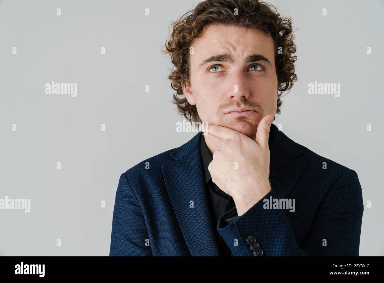 Brooding handsome man in eyeglasses thinking and looking upward ...